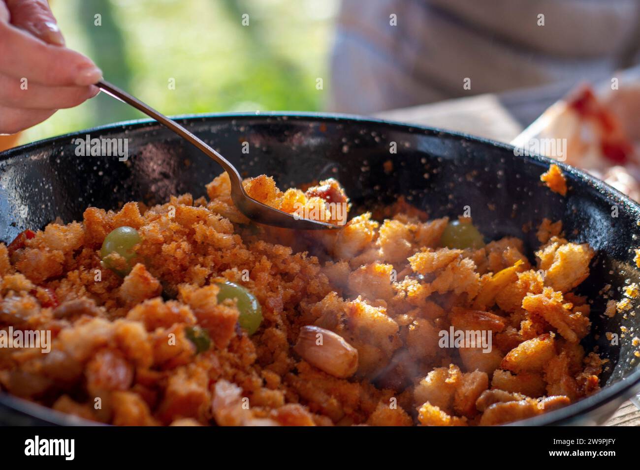 Cooking the typical Spanish dish of "Migas Castellanas" over a wood ...