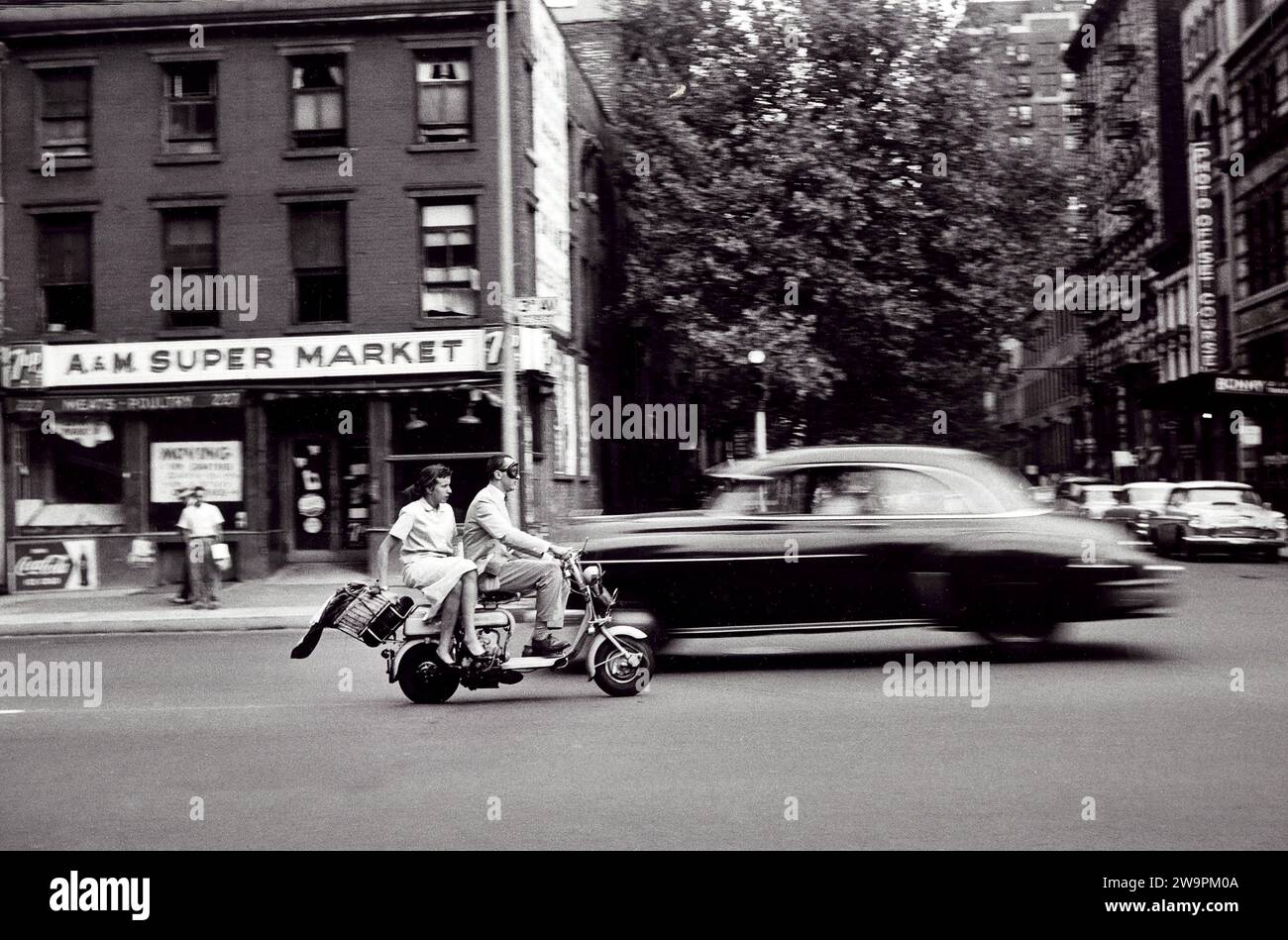 Man and woman on motorized scooter, A&M Super Market in background, New ...