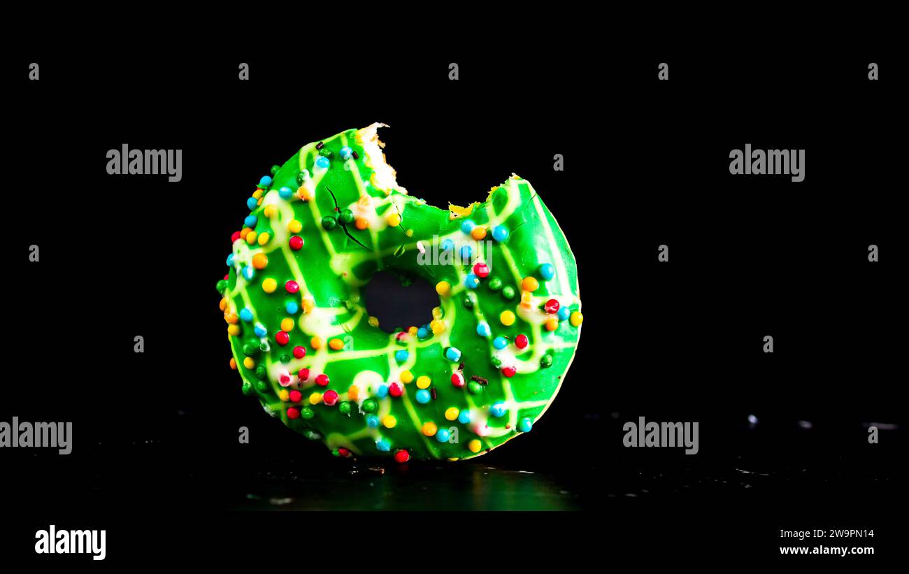 Green glazed donut with sprinkles isolated. Close up of colorful bitten donut Stock Photo - Alamy