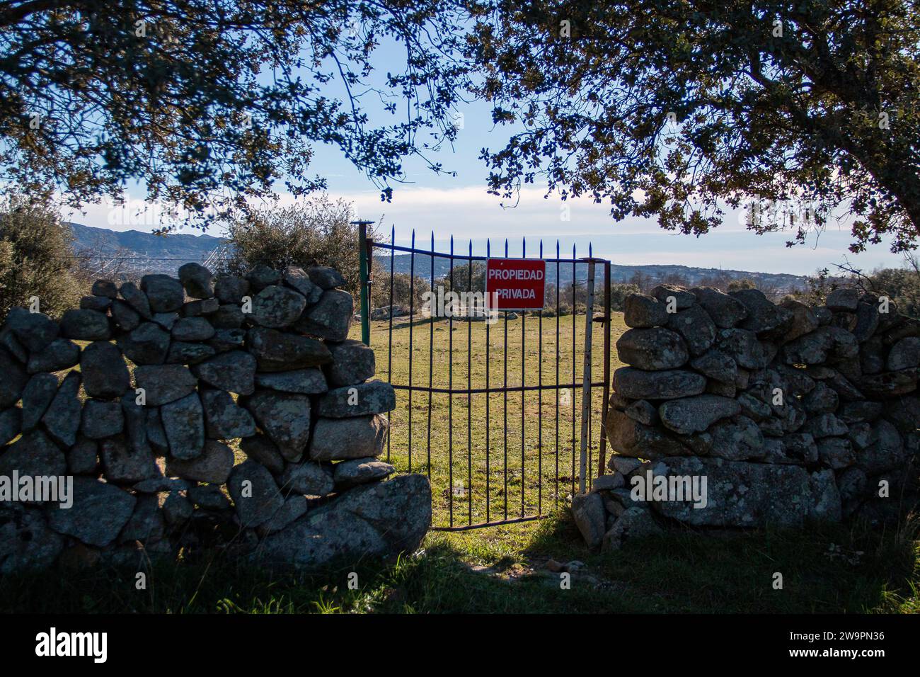 Translation: Private property. Iron bar gate on a dry stone fence that ...