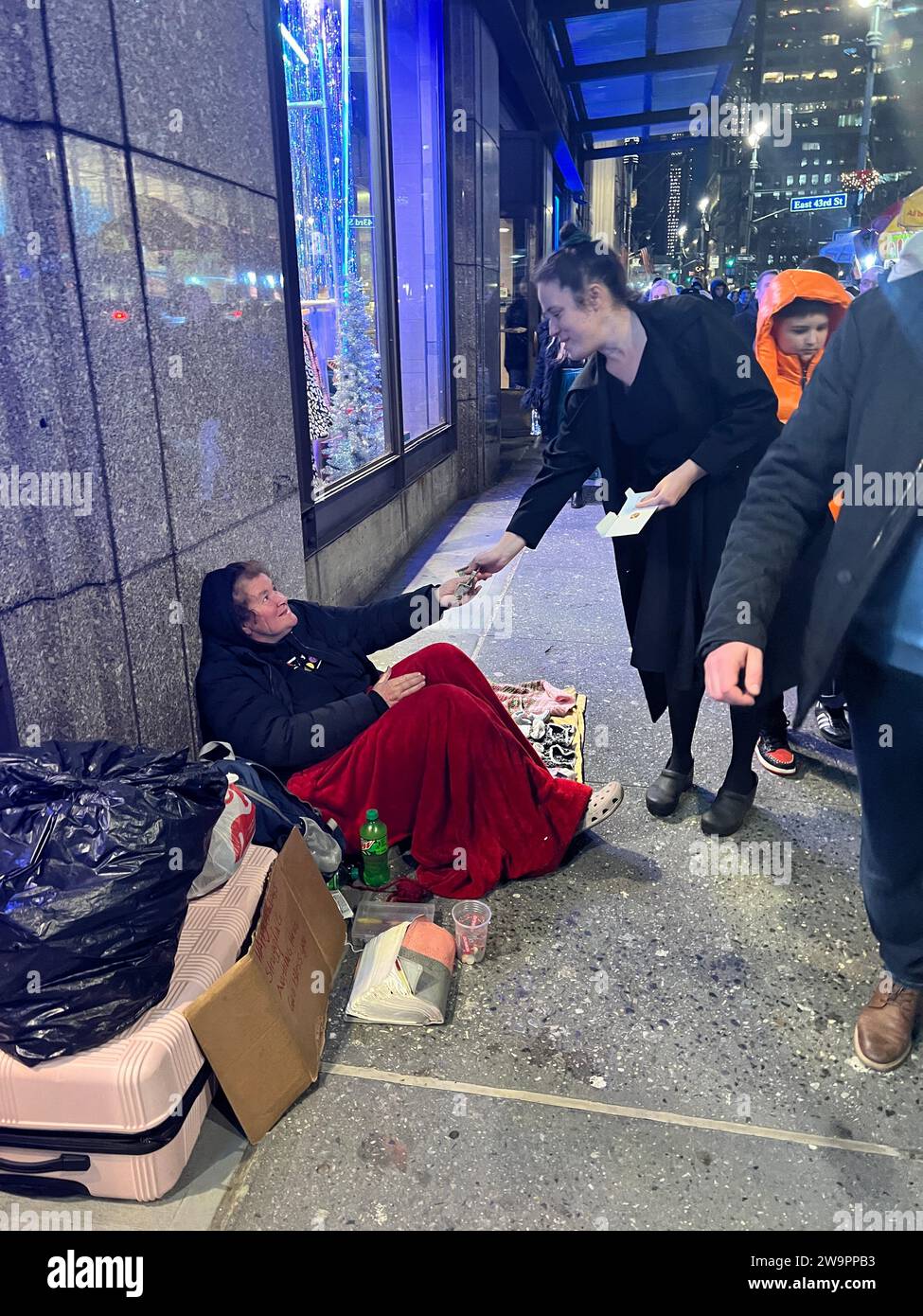 In the holiday spirit a woman gives a few dollars to a homeless older ...