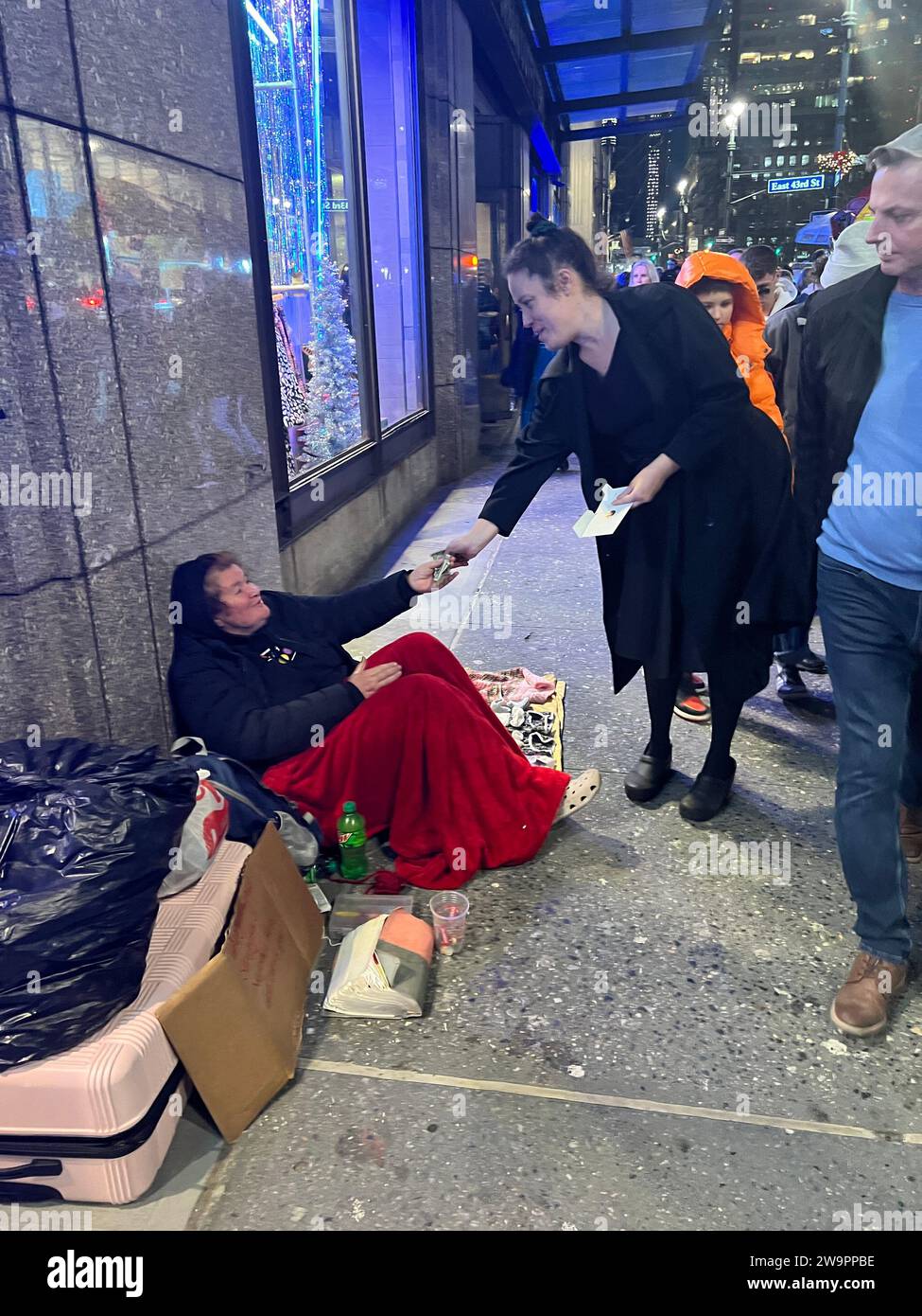 In the holiday spirit a woman gives a few dollars to a homeless older ...