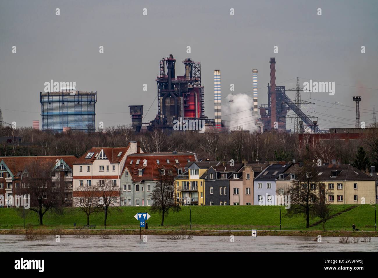 Rhine near Duisburg-Laar, houses on the dyke road, industrial backdrop ...
