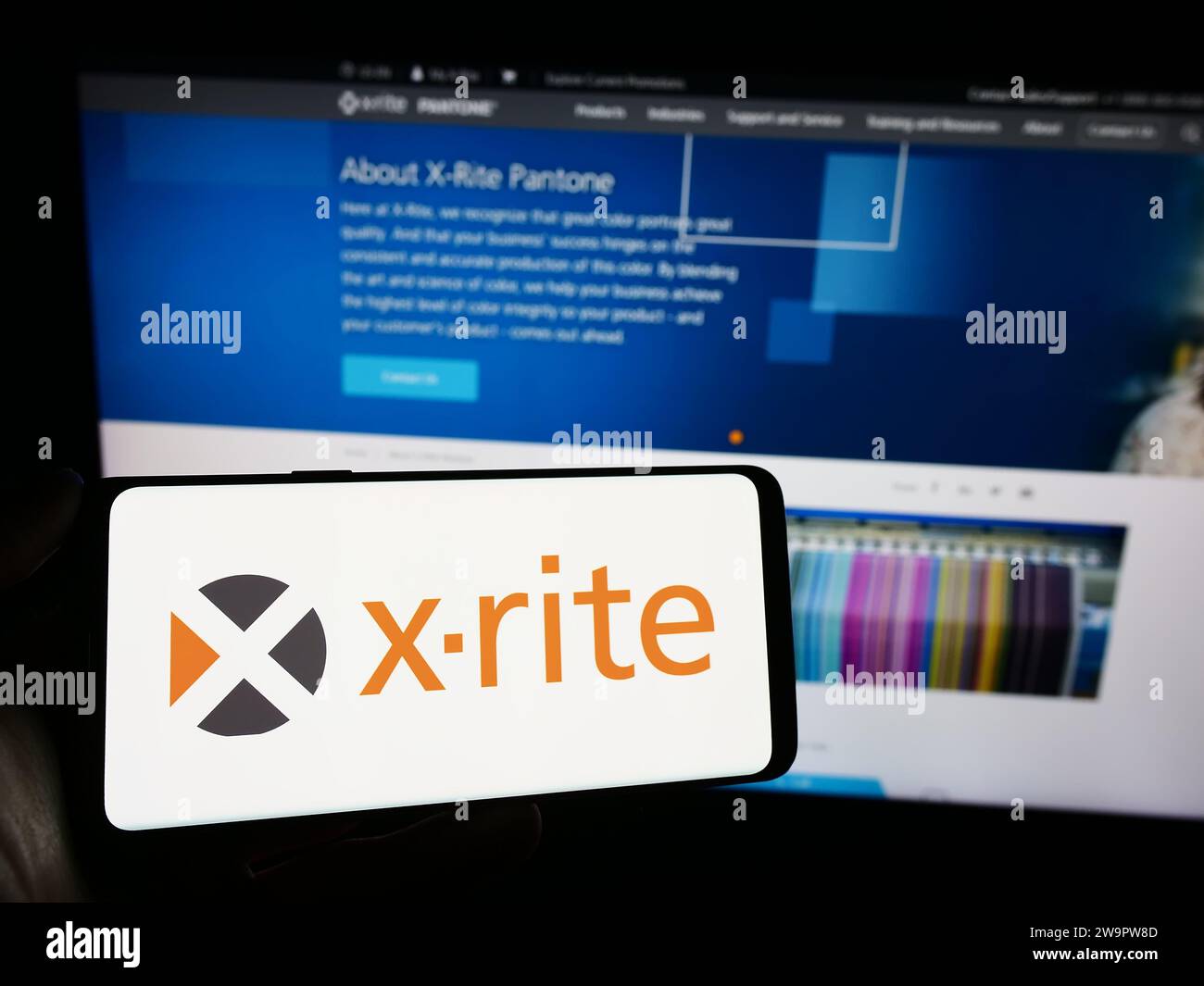 Person holding mobile phone with logo of American color products X-Rite ...