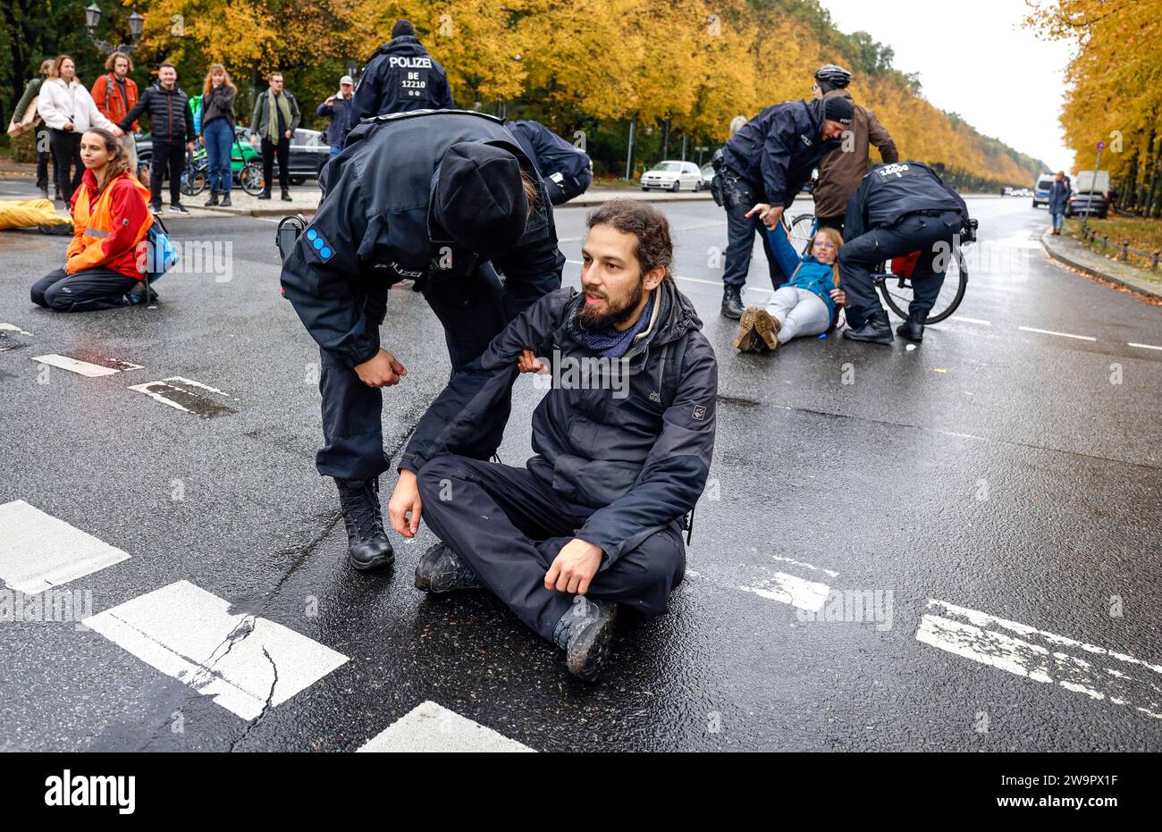 Police officers carry last generation climate activists from Strasse ...