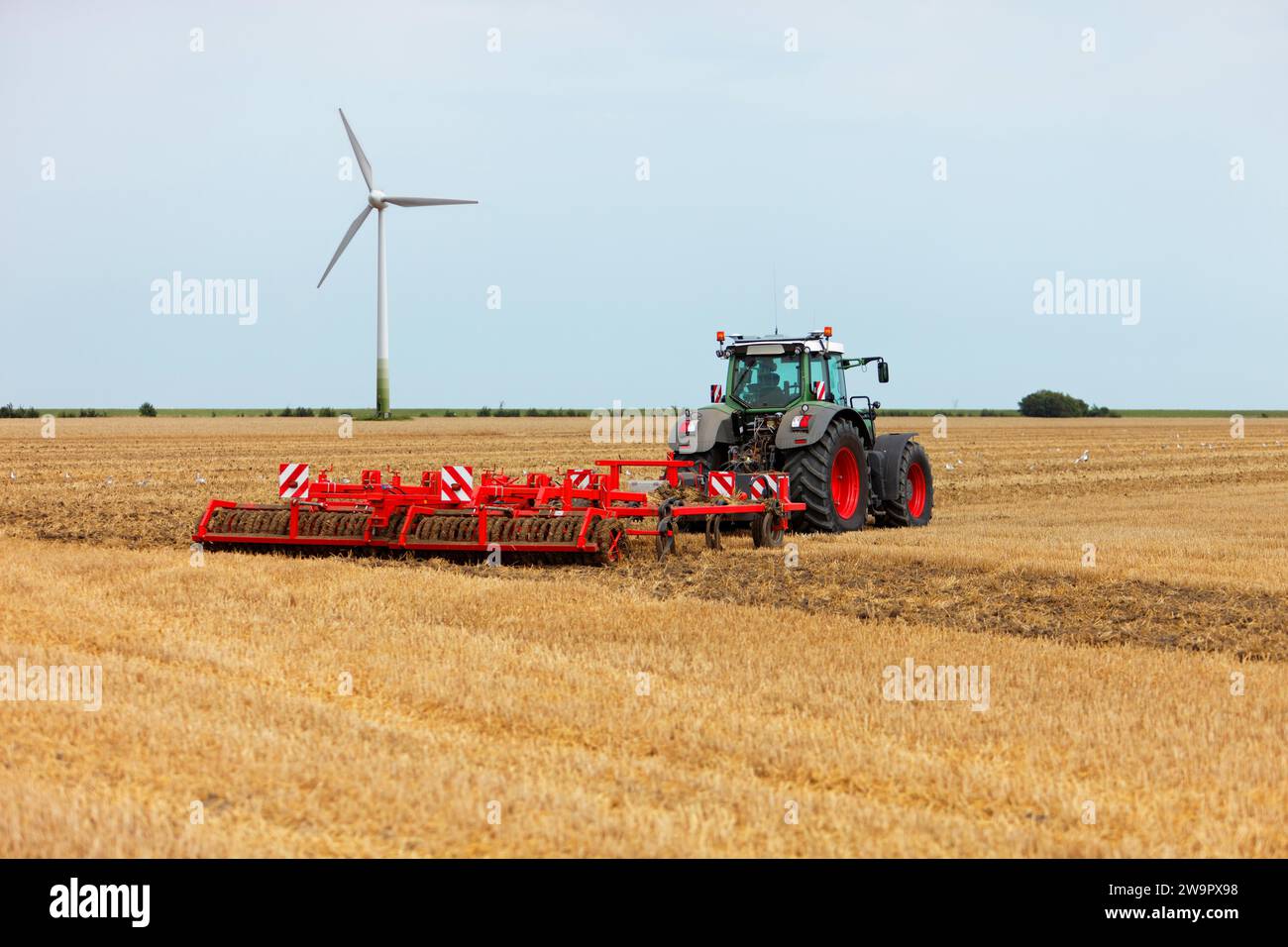Tractor pulls a harrow behind it Stock Photo - Alamy