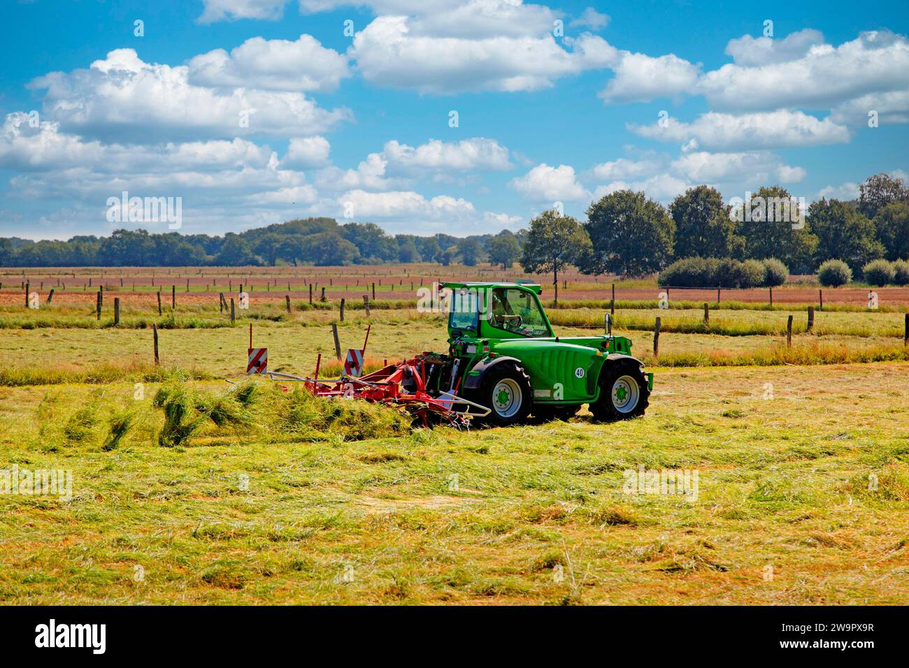 A farmer with his tractor and hay tedder Stock Photo - Alamy
