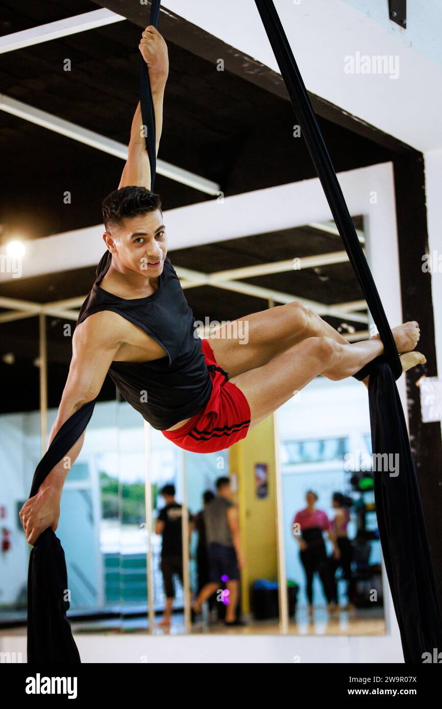 Draped in silken threads, the aerial performer effortlessly executes ...