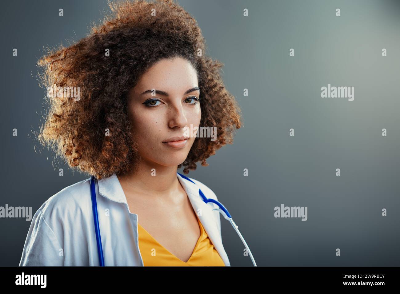 Curly-haired doctor, in clinical attire, displays a subtle ...