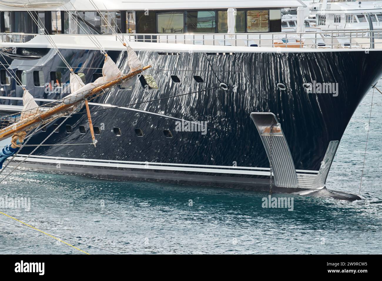 Sun glare on glossy board of mega yacht, anchor, tranquillity in port ...