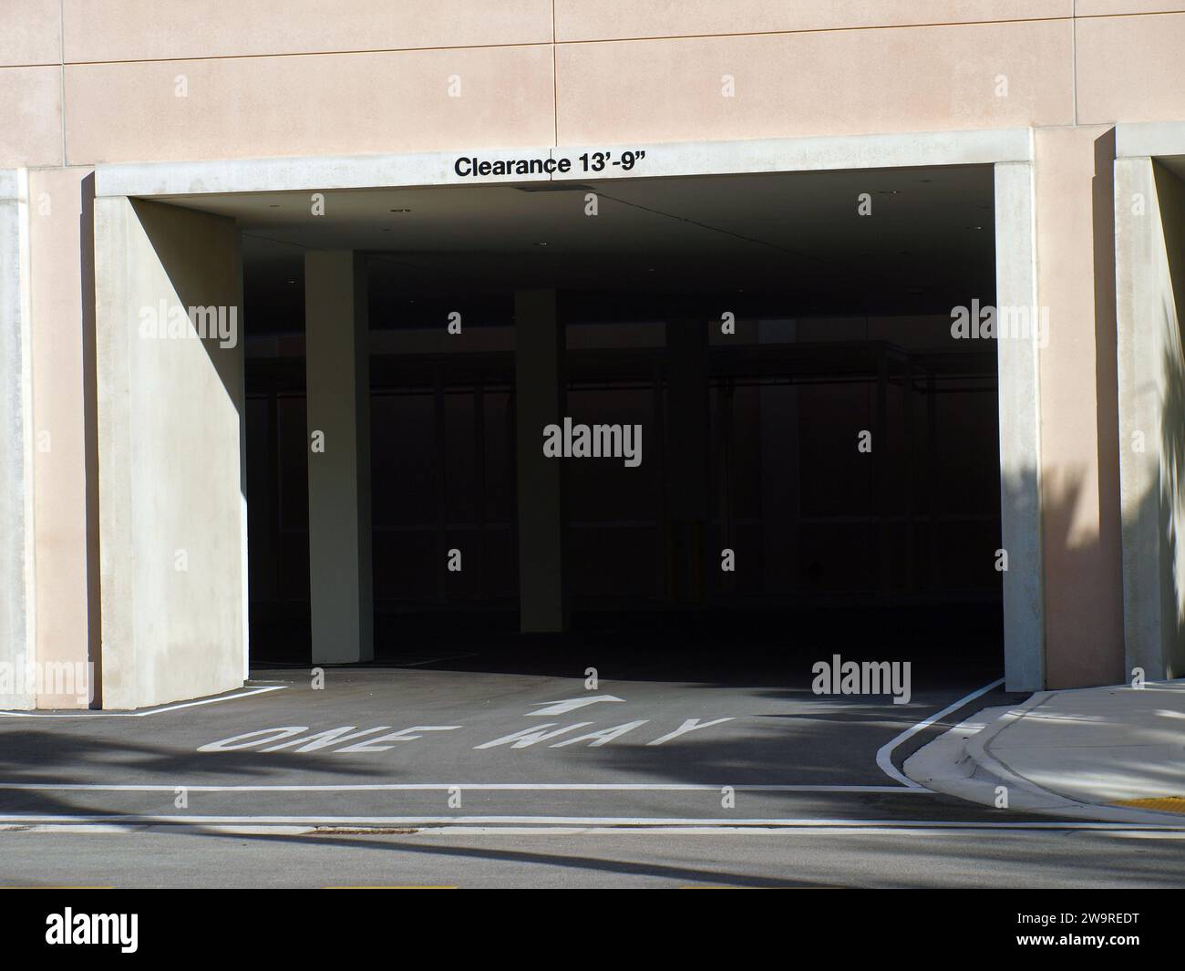 Parking entrance with clearance sign on top and one way direction ...