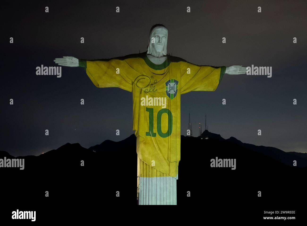 The Christ the Redeemer statue is illuminated with an image of Pele's ...