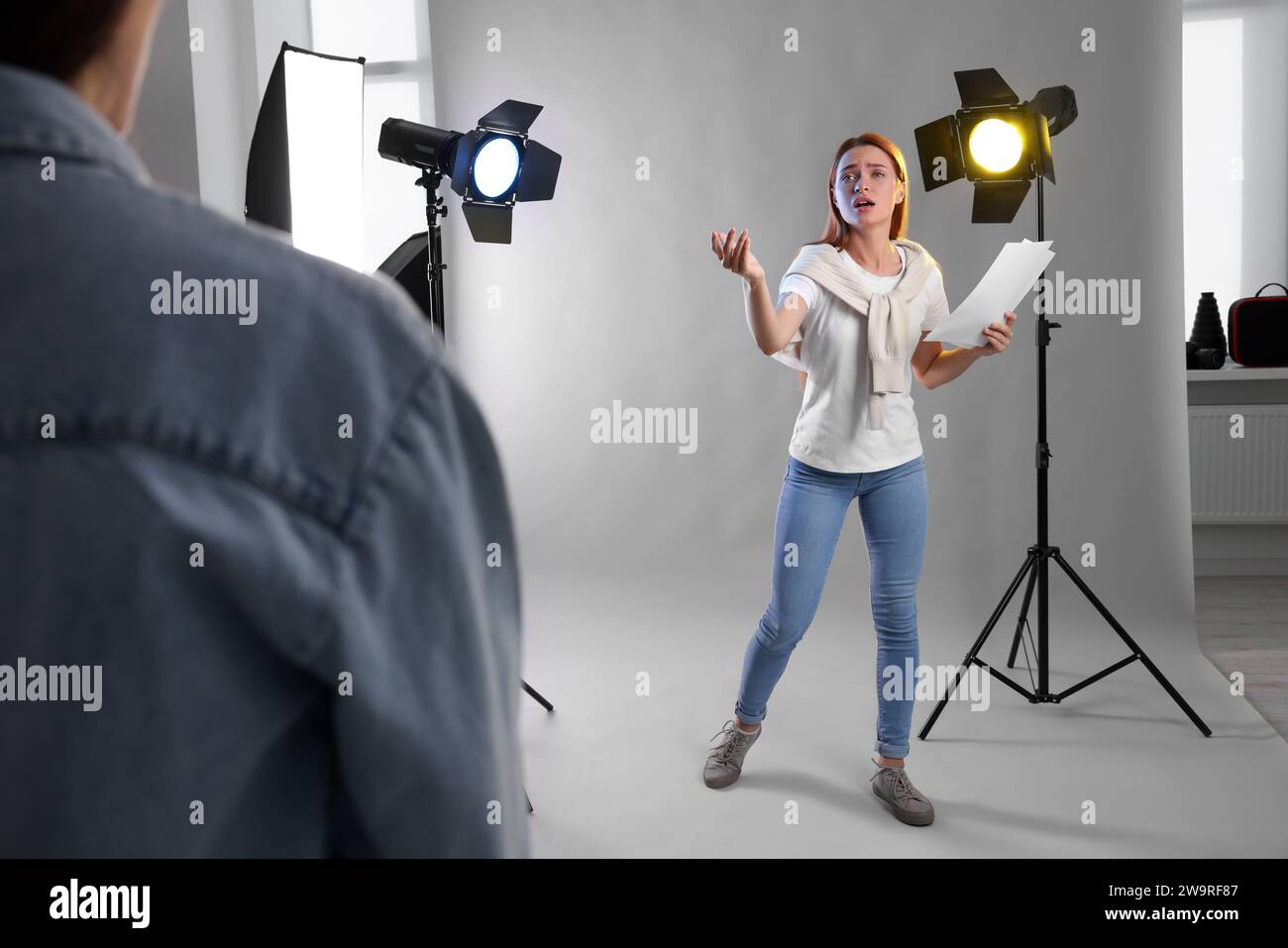 Emotional woman with script performing in front of casting director ...