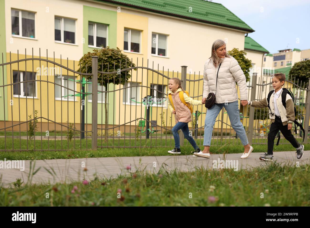 Being late for school. Senior woman and her grandchildren with ...