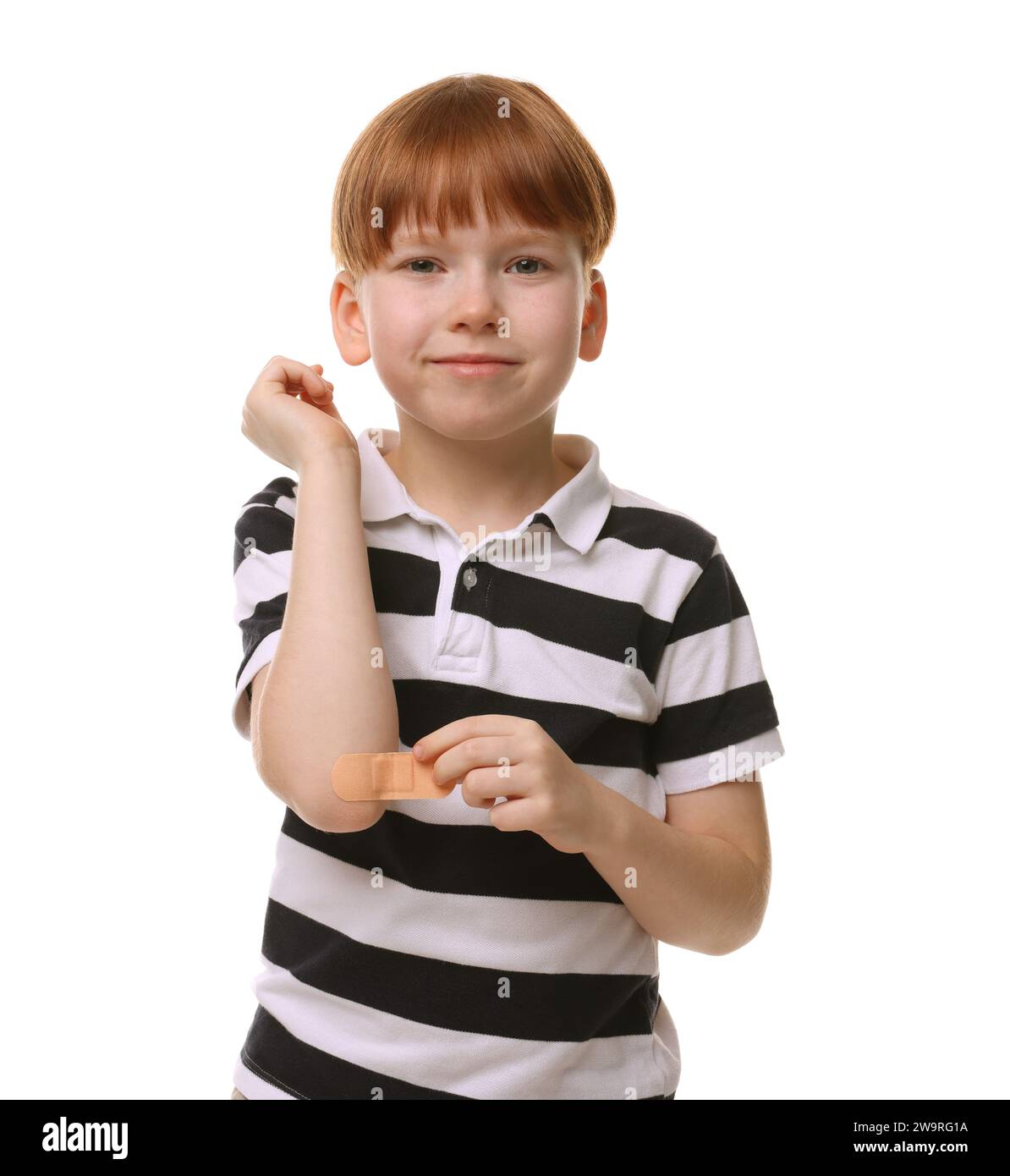 Little boy putting sticking plaster onto elbow on white background ...