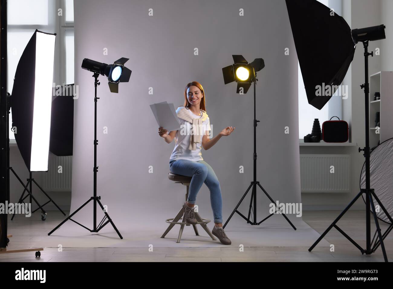 Casting call. Young woman with script performing on grey background in ...