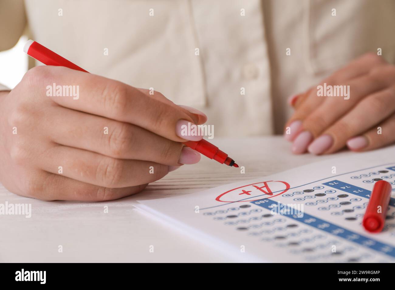 School grade. Teacher writing letter A with plus symbol on answer sheet ...