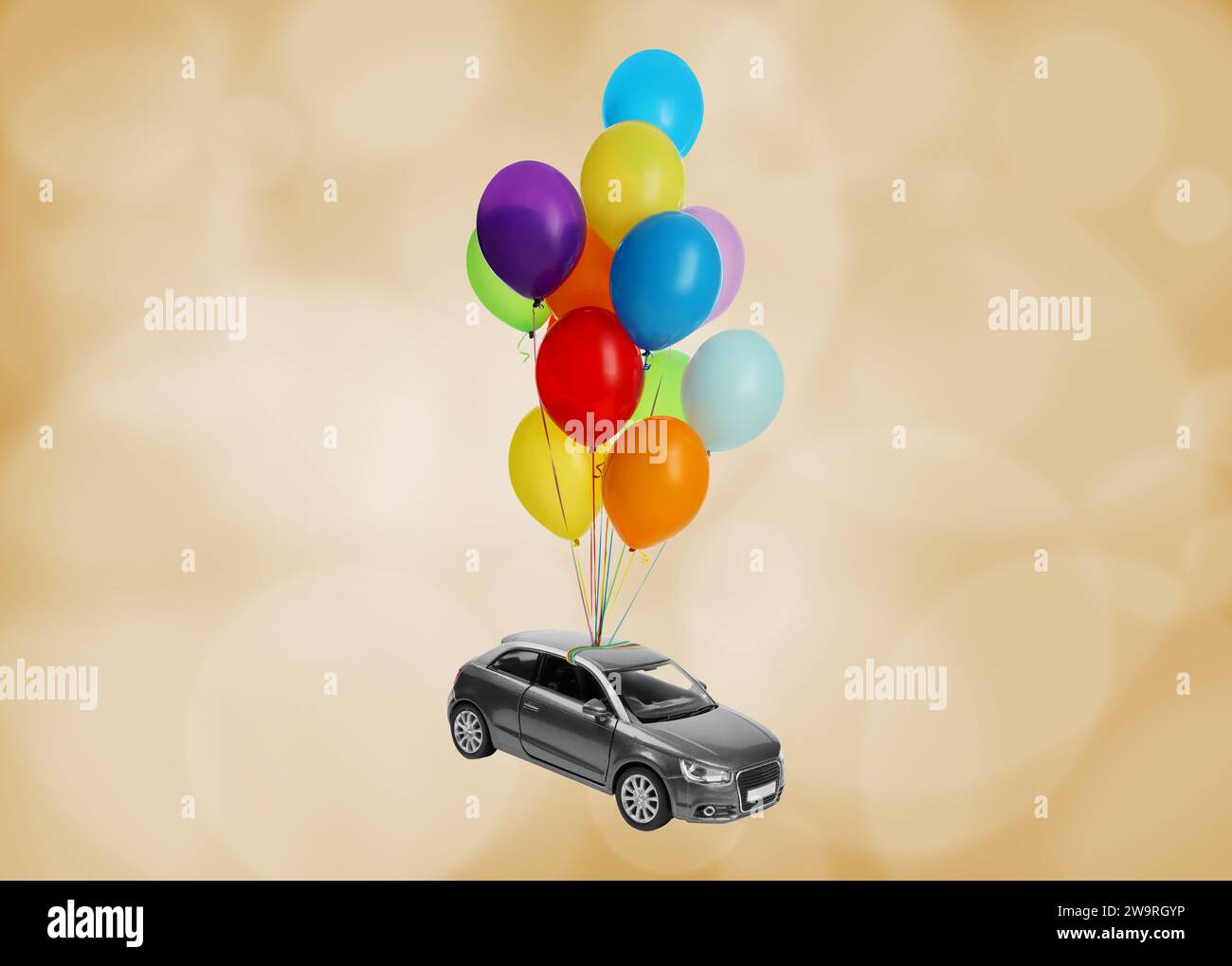 Many balloons tied to toy car flying on golden background Stock Photo ...