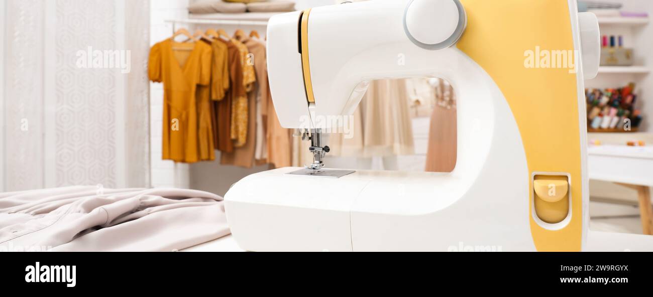 Sewing machine and fabric on table in dressmaking workshop. Banner ...