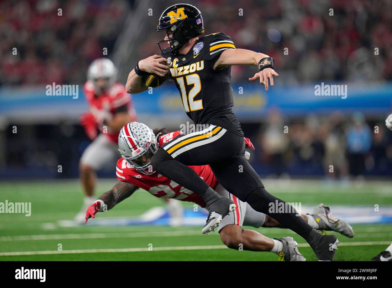 Missouri quarterback Brady Cook (12) runs next to Ohio State linebacker ...