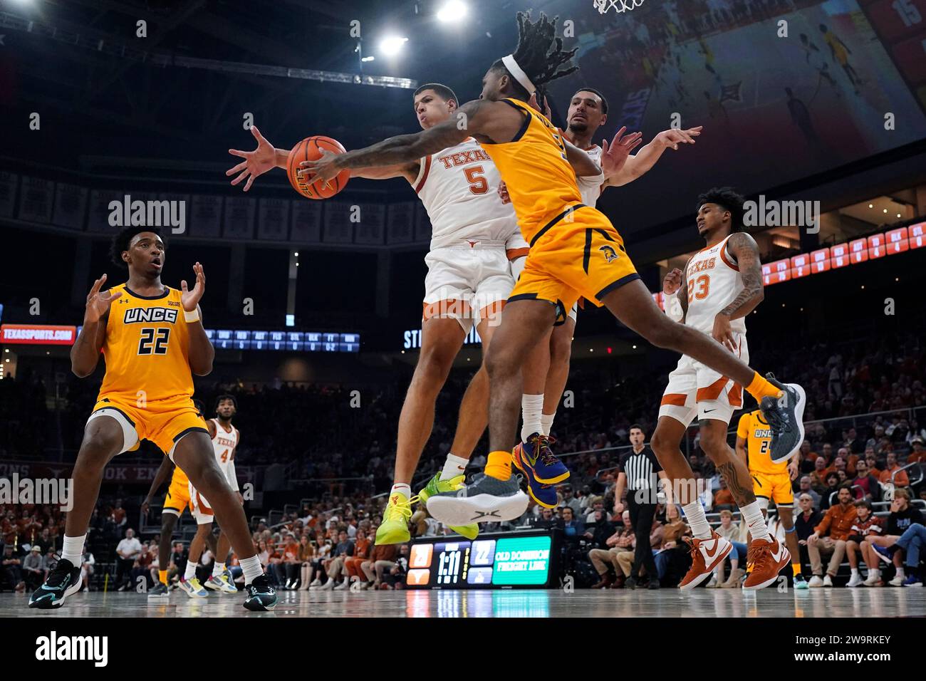 UNC Greensboro guard Kobe Langley (3) passes the ball around Texas ...