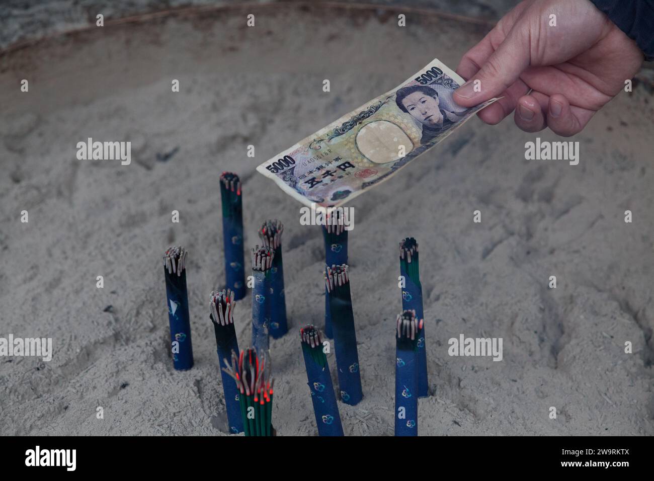 A 5,000 yen Japanese bank note is blessed with incense at Benzaiten ...