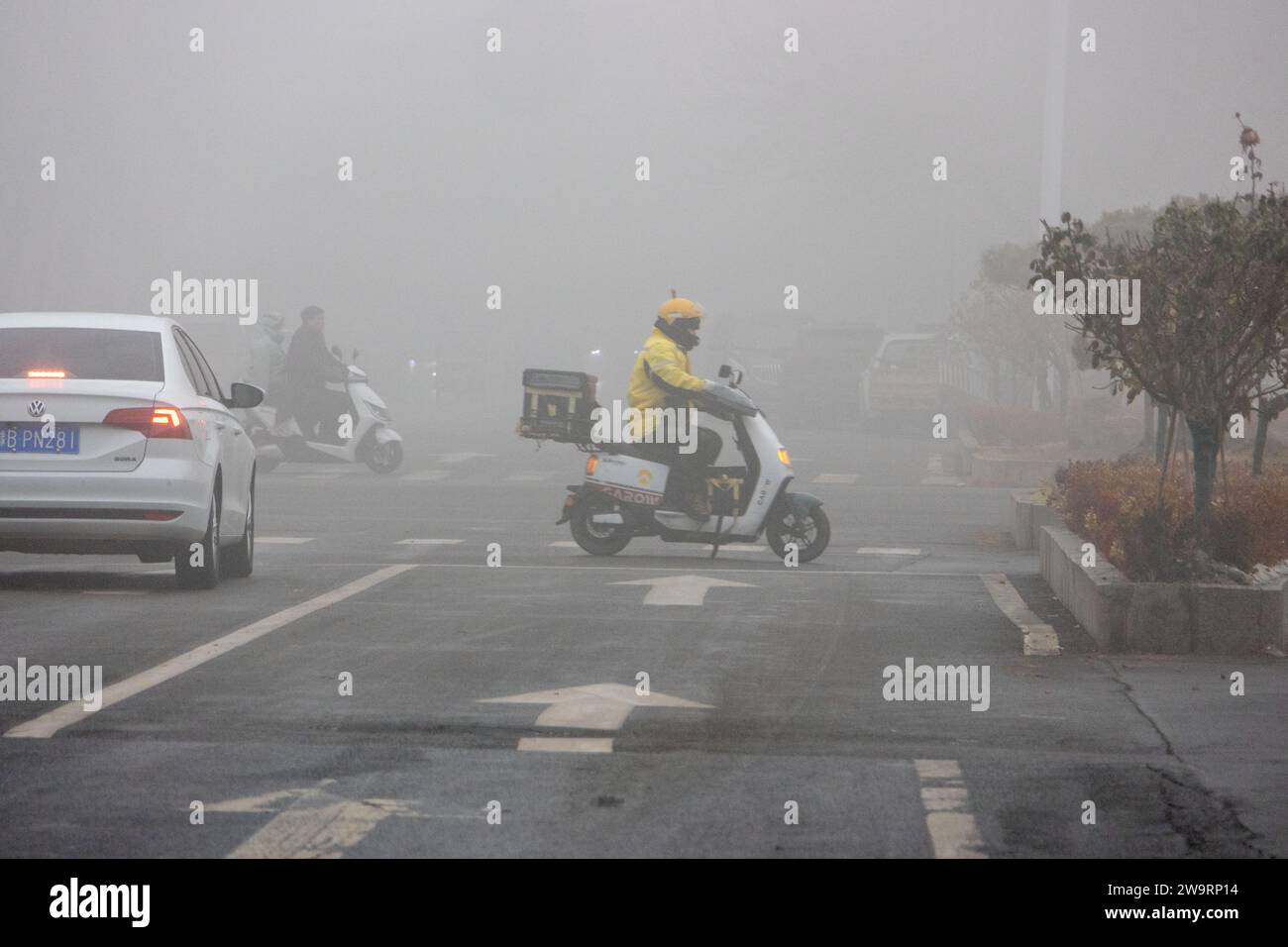 ANYANG, CHINA - DECEMBER 30, 2023 - People travel in heavy fog with ...
