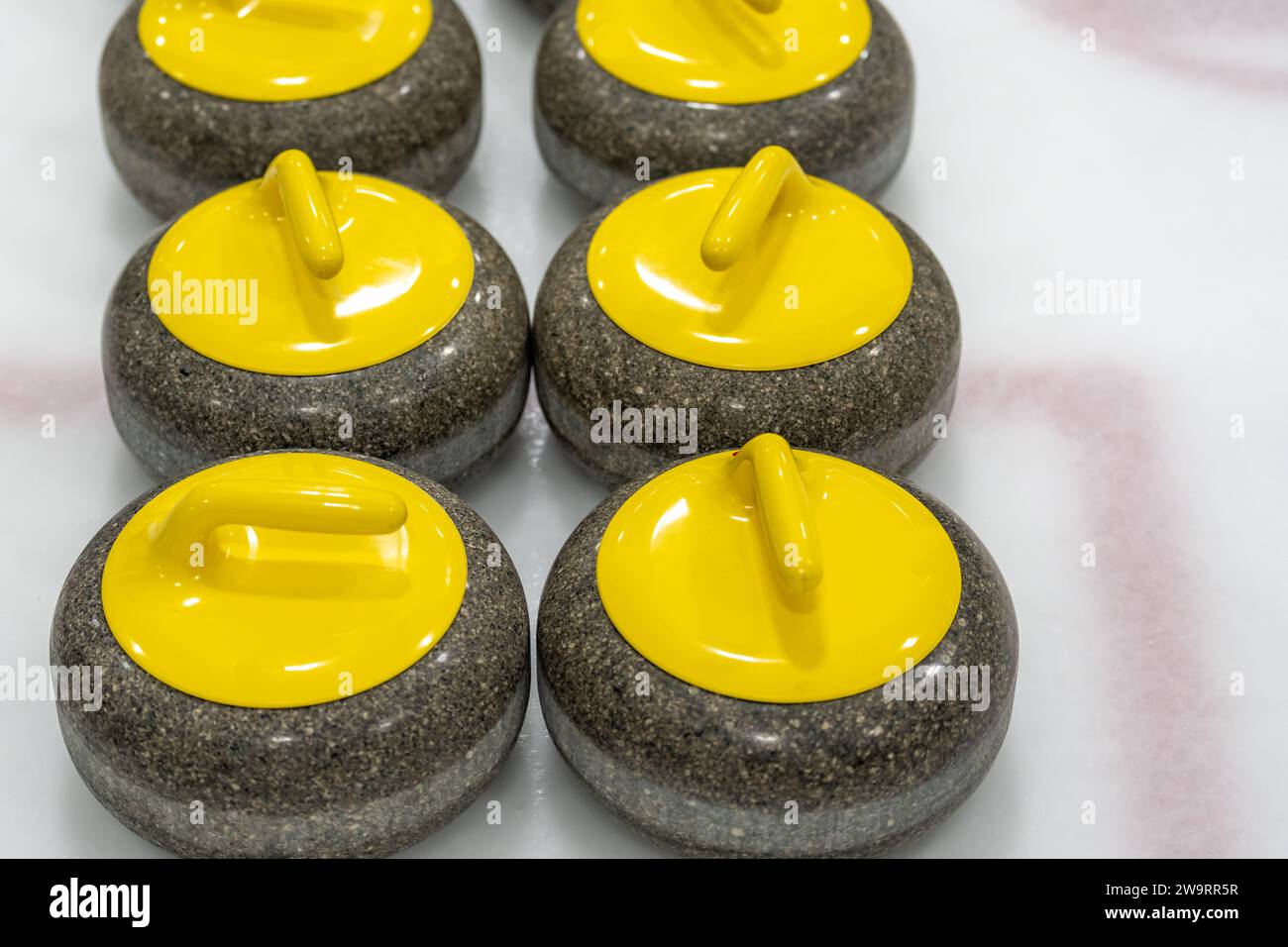 Curling rocks on ice Stock Photo - Alamy