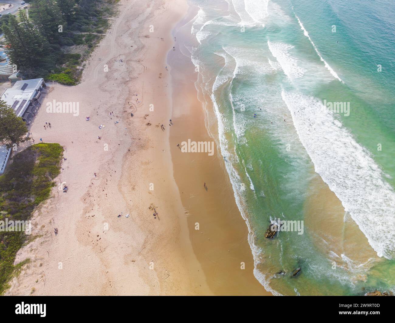Aerial view of waves rolling onto a wide sandy beach at Tathra on the ...