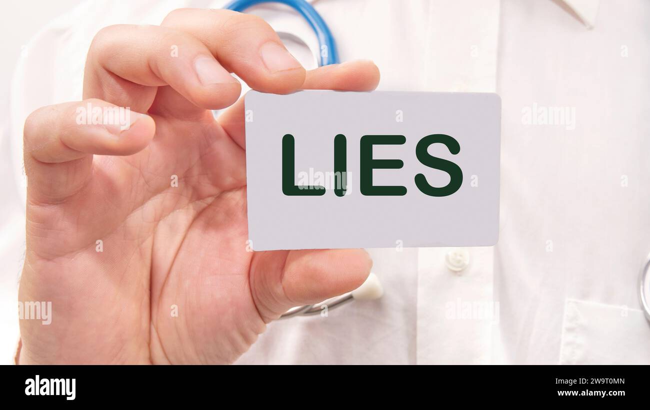 Lies word on the card in a man's hand on the background of a white ...