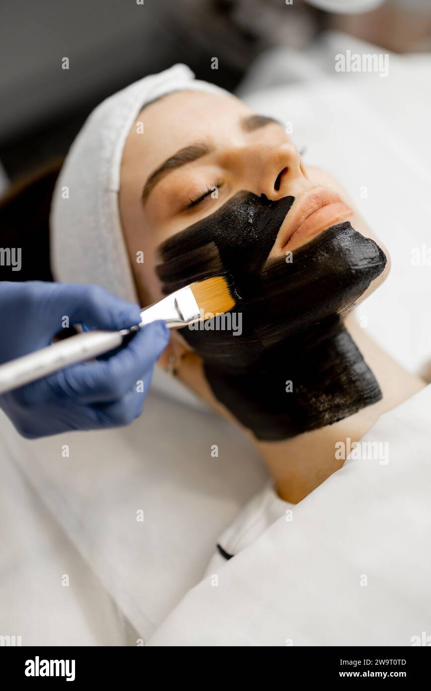 Applying carbon mask to a woman's face Stock Photo - Alamy