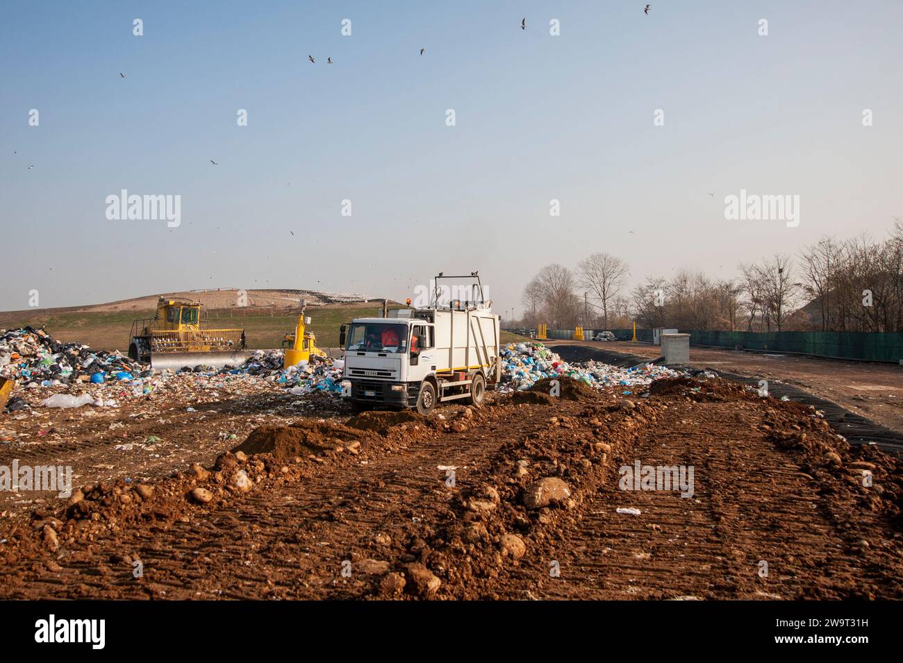 Municipal waste landfill. Workers with trucks and bulldozers at work in ...