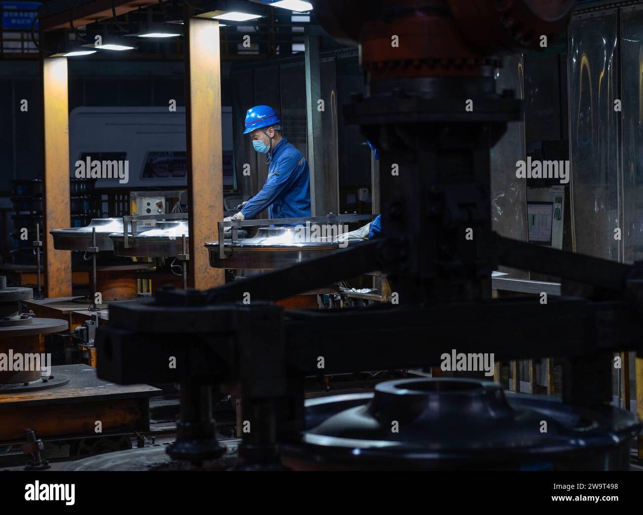 (231230) -- MA'ANSHAN, Dec. 30, 2023 (Xinhua) -- An employee measures ...