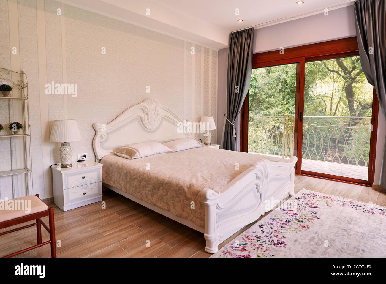 Large double bed with bedside tables in a room with panoramic windows ...