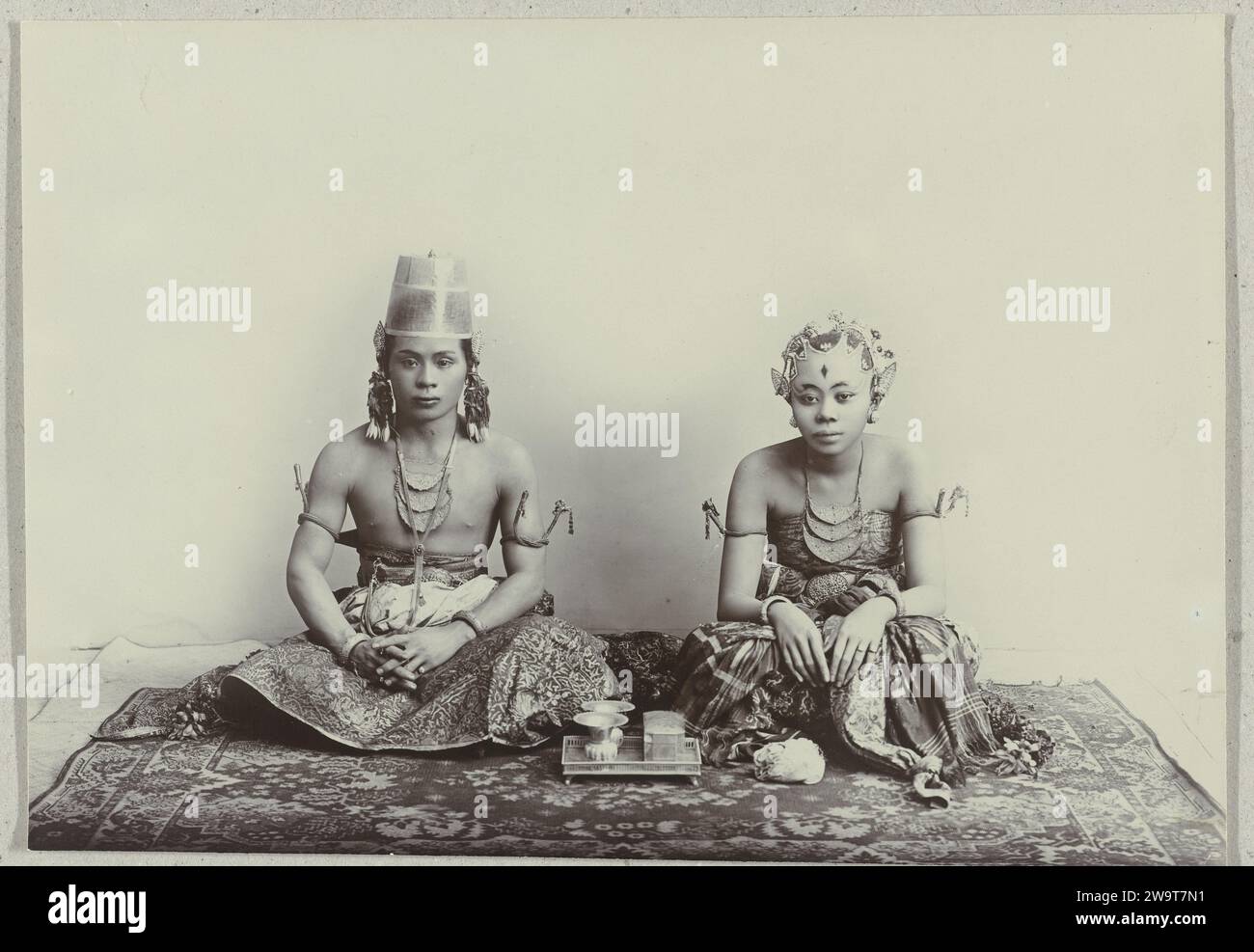 Studio portrait of a sitting young Javanese man and wife bearing a ...