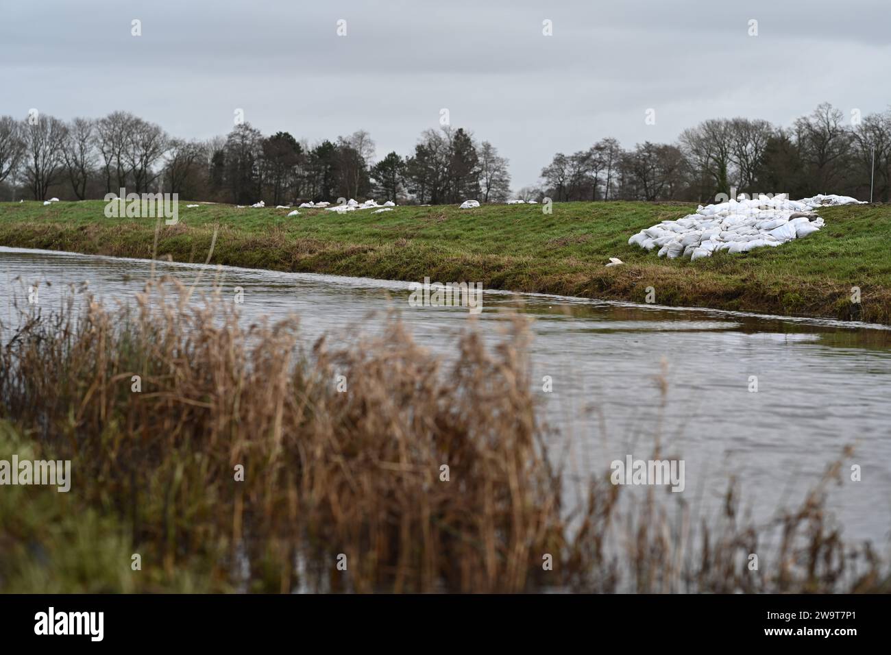Hollen, Germany. 30th Dec, 2023. Sandbags are lying on the river ...
