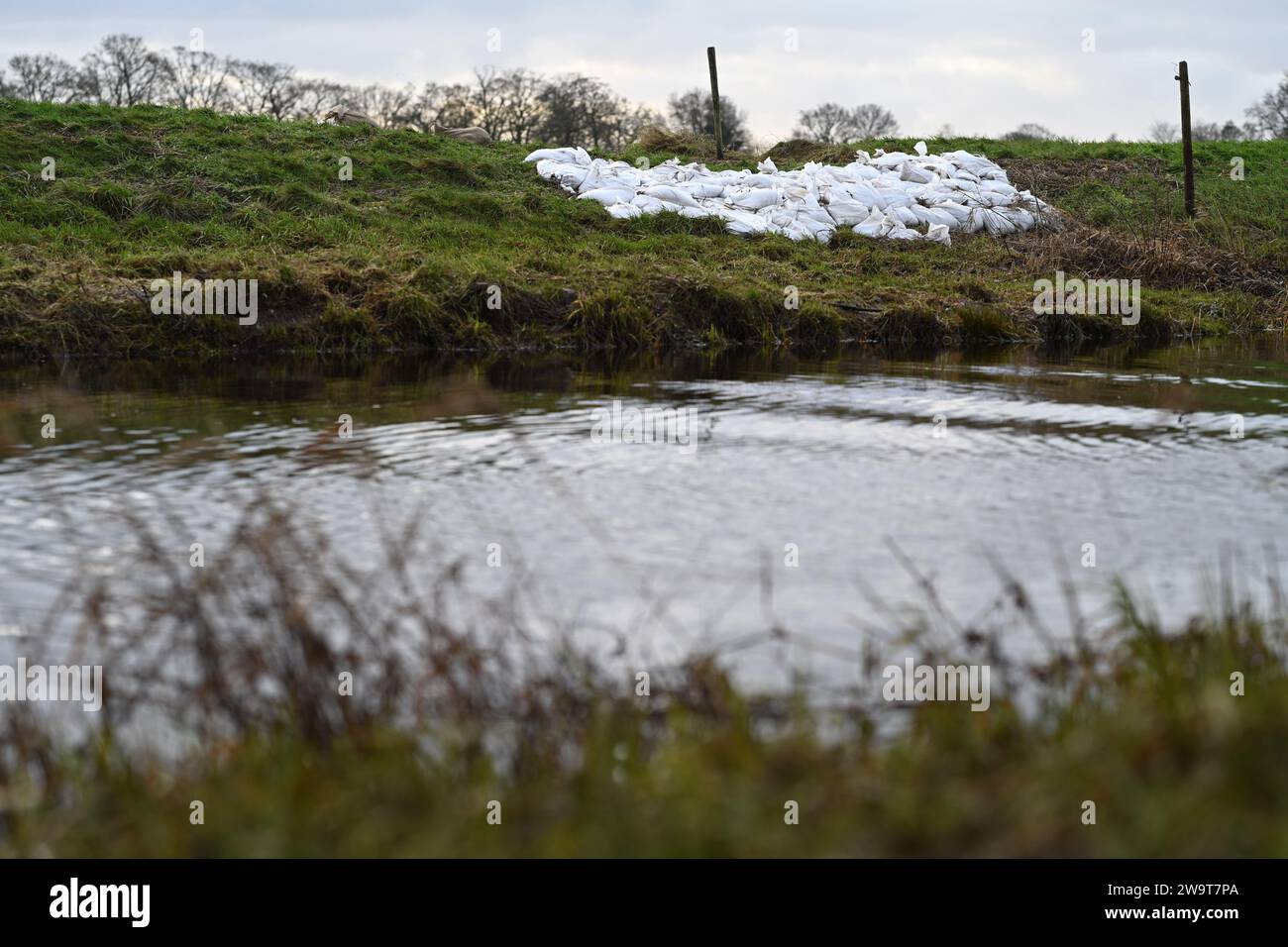 Hollen, Germany. 30th Dec, 2023. Sandbags are lying on the river ...