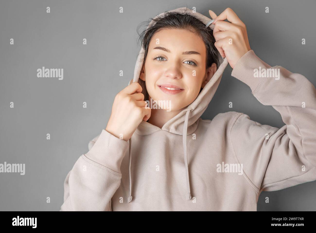 Portrait of a young pretty smoling girl in a hoodie Stock Photo - Alamy