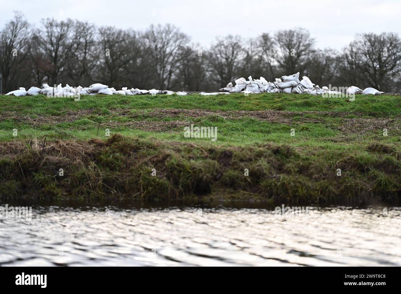 Hollen, Germany. 30th Dec, 2023. Sandbags are lying on the river ...