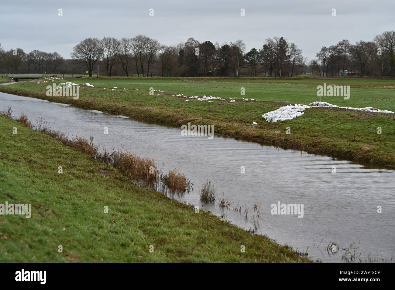 Hollen, Germany. 30th Dec, 2023. Sandbags are lying on the river ...