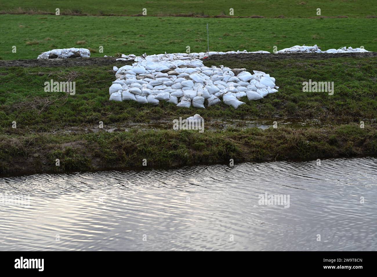 Hollen, Germany. 30th Dec, 2023. Sandbags are lying on the river ...