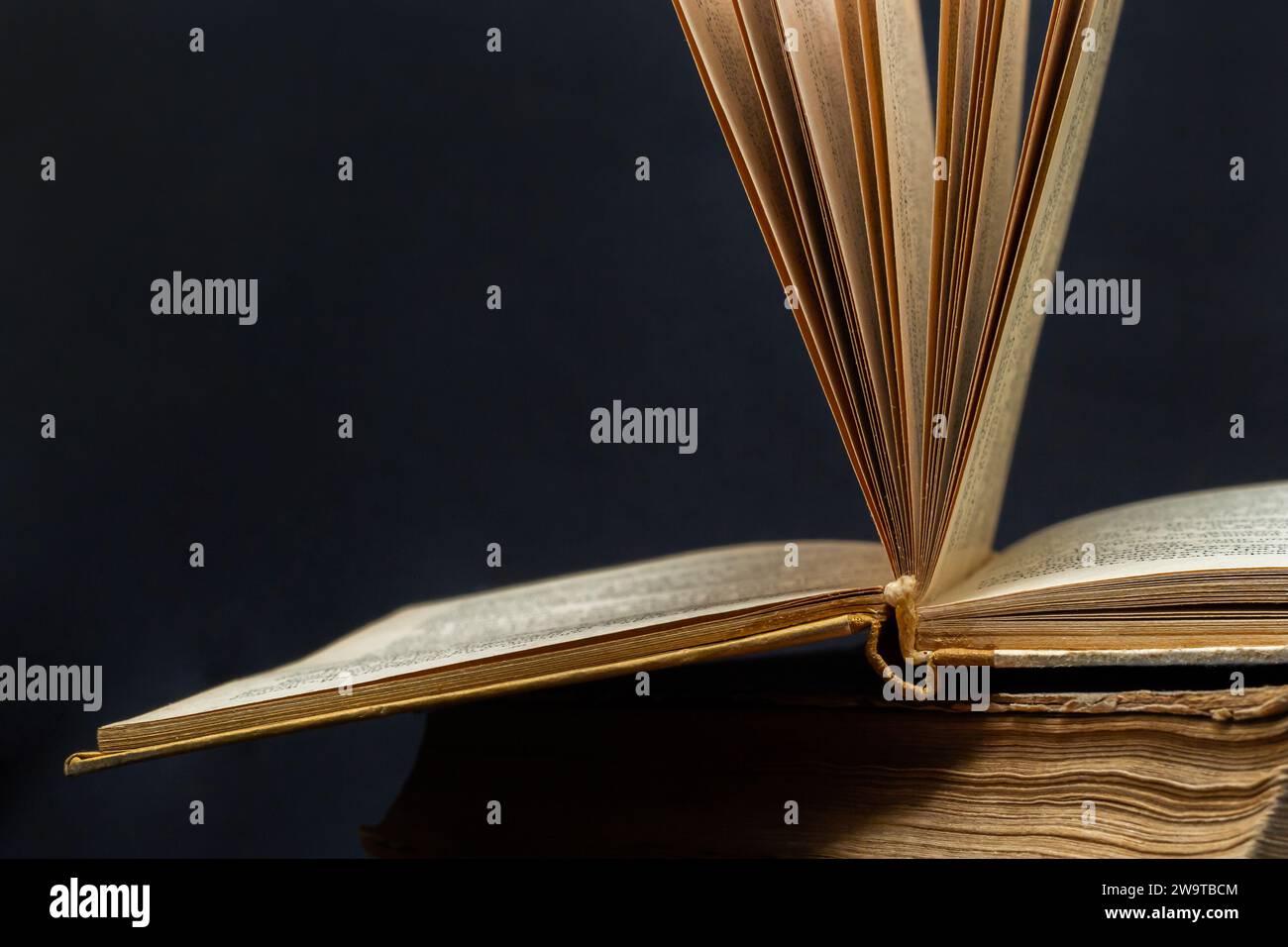 stack of old books with opened one on top on dark background. Old books ...