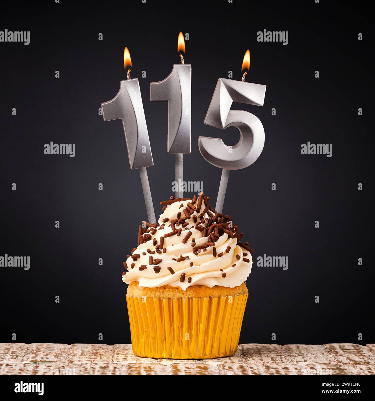 Birthday candle number 115 - Anniversary cupcake on black background ...