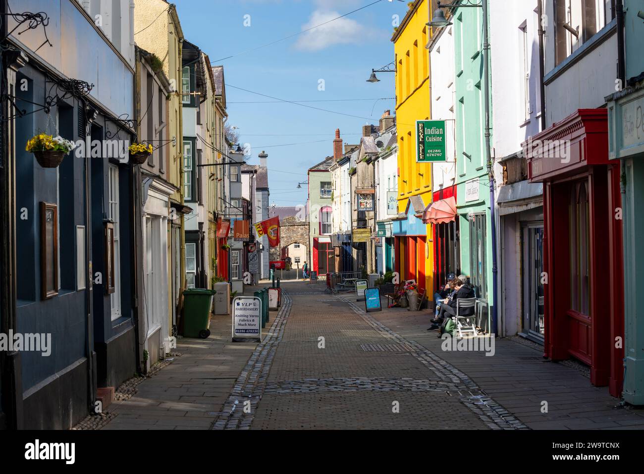 Shops in a narrow street in the historic walled town of Caernarfon ...