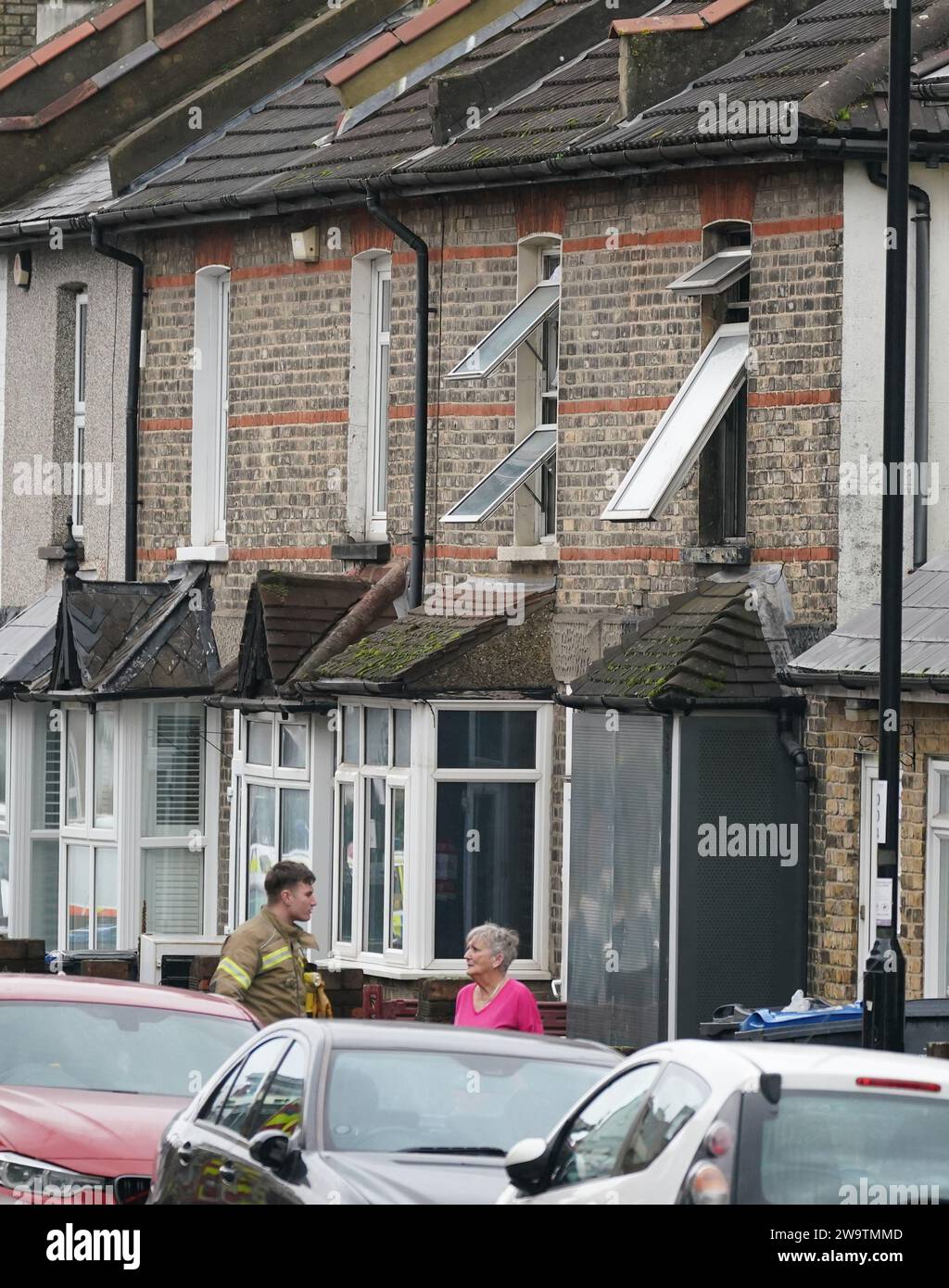 A firefighter speaks to a resident outside a property on Sanderstead ...