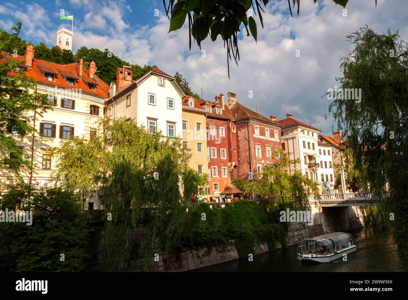 Riverside street and bridge below castle hill in Ljubljana in Slovenia ...