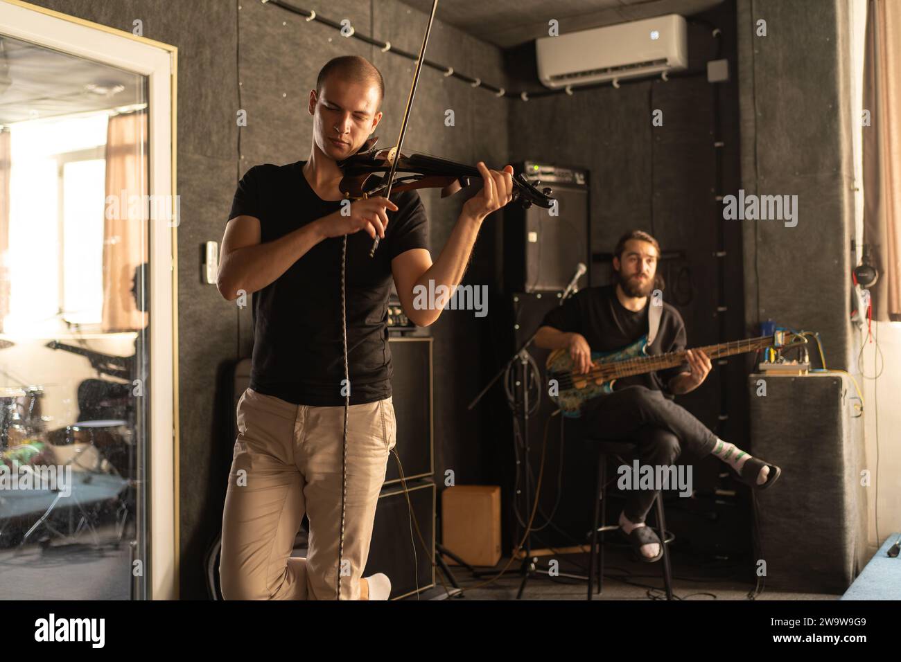 Music band repetition. Violinist and guitarist tune musical instruments ...