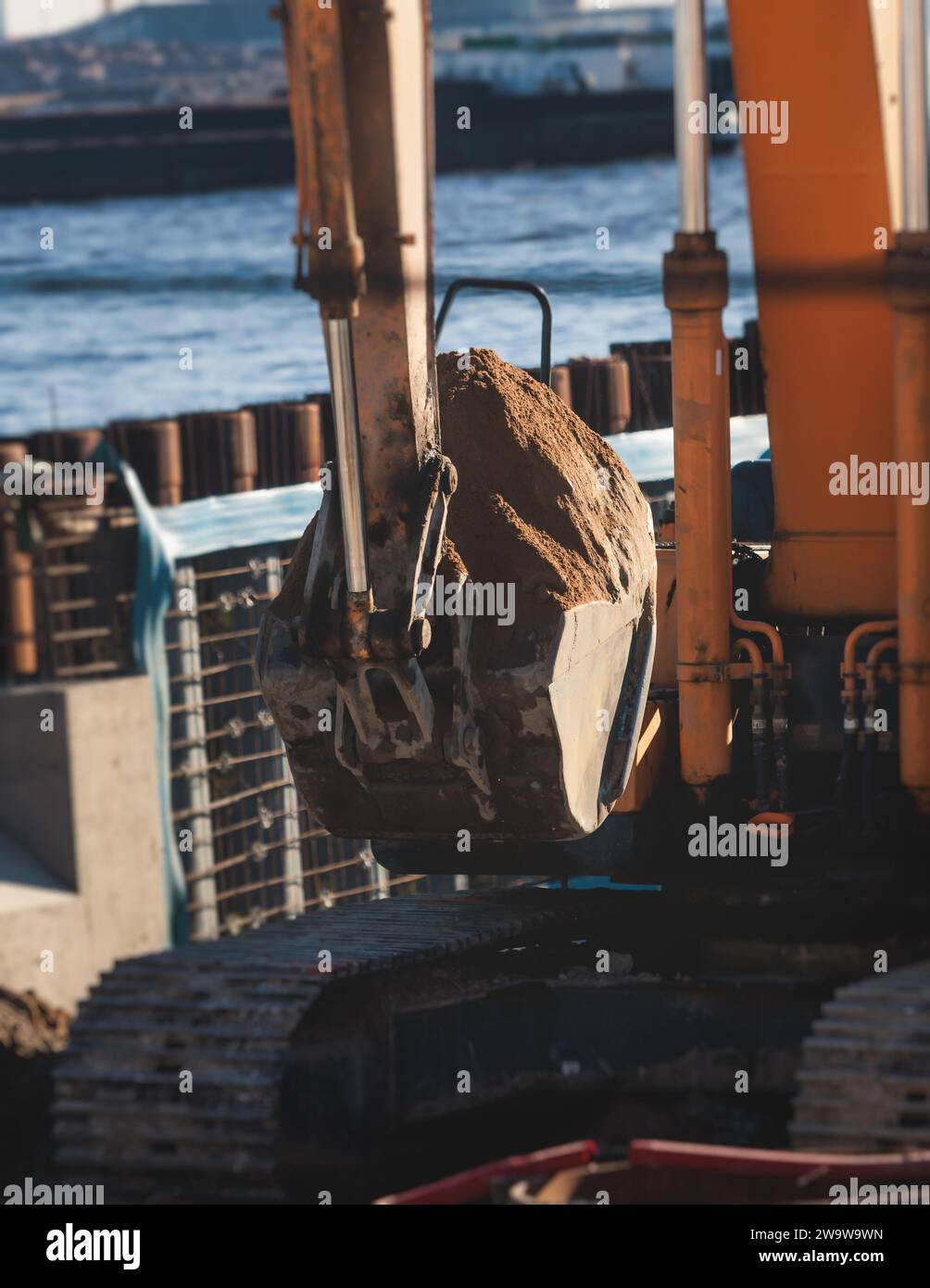 Excavator unloading sand into the dump truck on the construction site ...