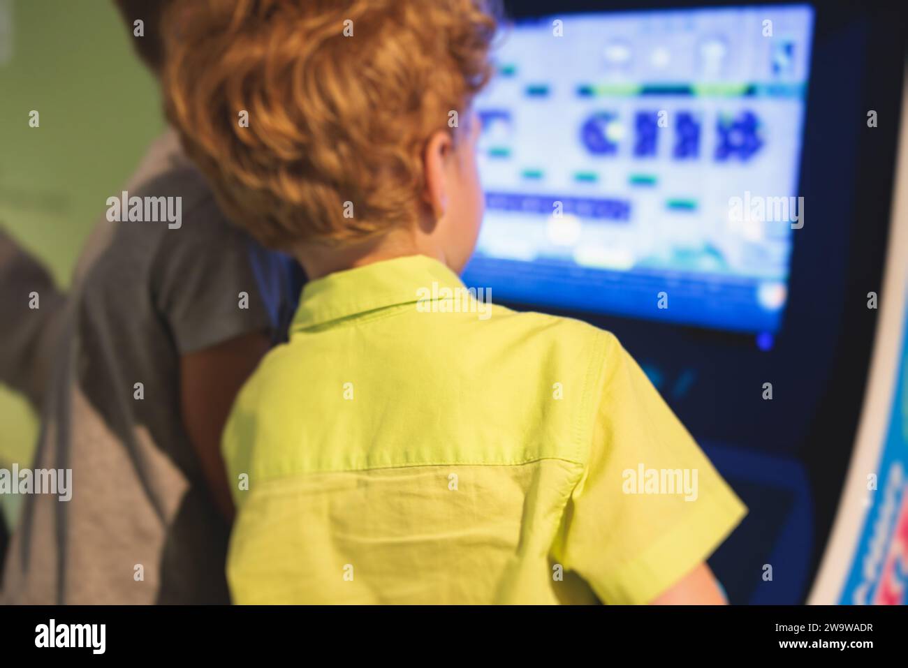 Kids play slot machine at amusement theme park, children play arcade ...