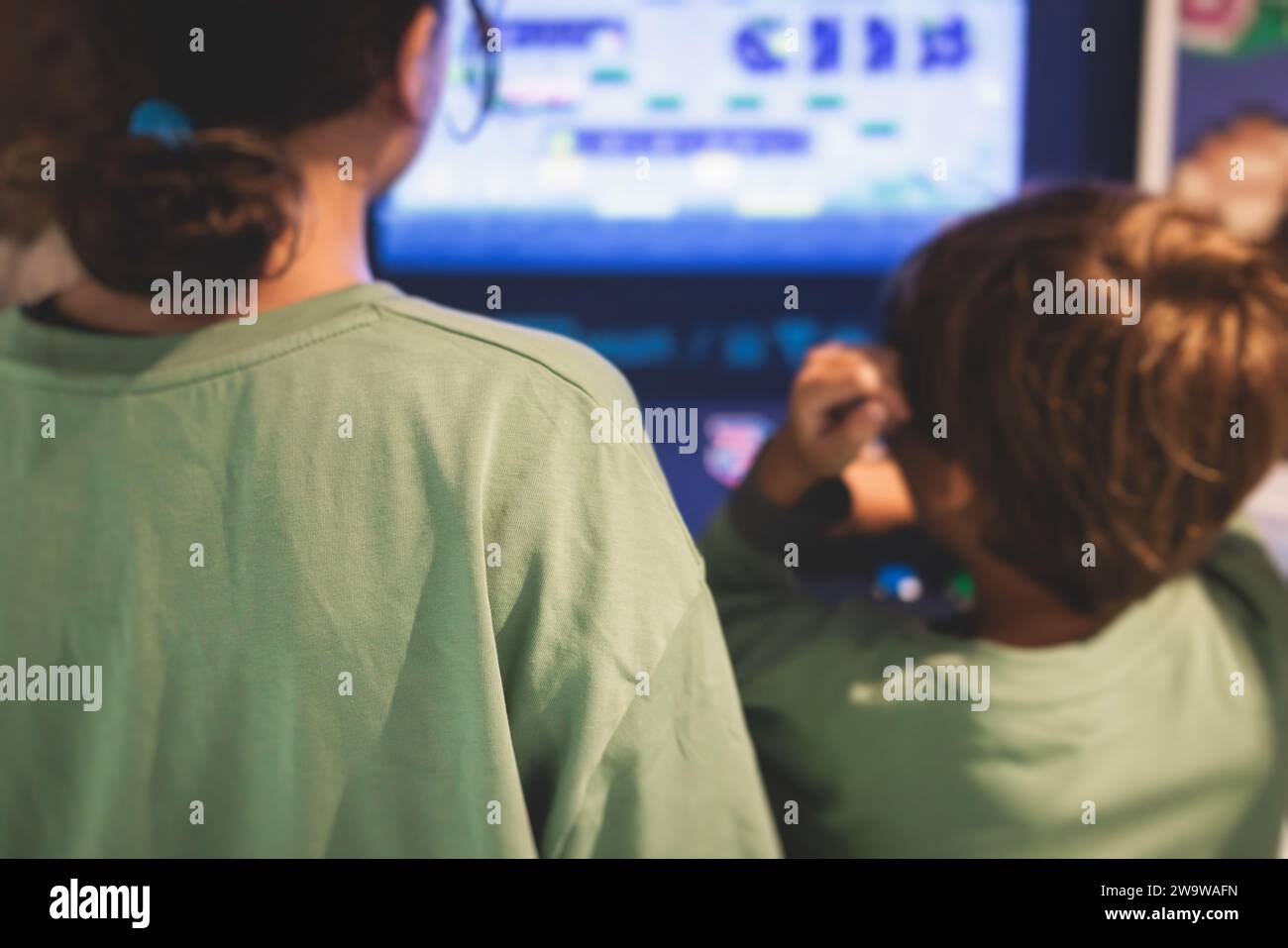 Kids play slot machine at amusement theme park, children play arcade ...